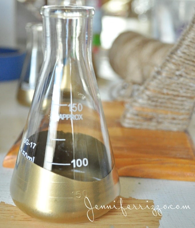 a lab beaker spray painted with gold paint for a vase - Jennifer Rizzo